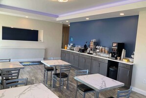 Cozinha moderna com bancadas de mármore, armários cinza e uma estação de café integrada.