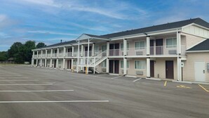 Um motel com vários andares, estacionamento e céu claro.