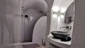 Casa de banho moderna com lavatório curvo, espelho e zona de duche.