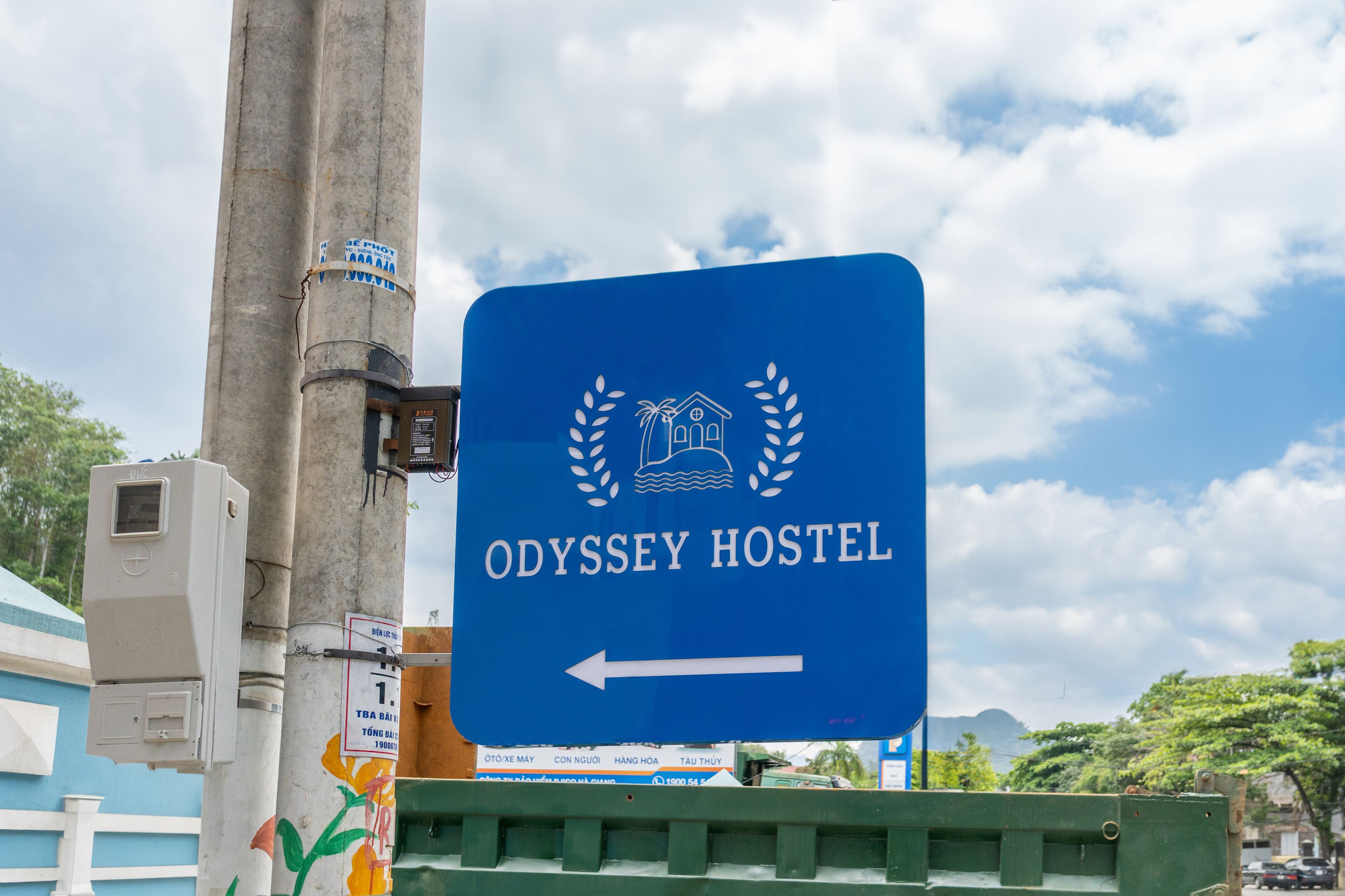 Placa indicativa do Odyssey Hostel com uma seta.