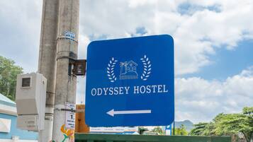 Placa indicativa do Odyssey Hostel com uma seta.
