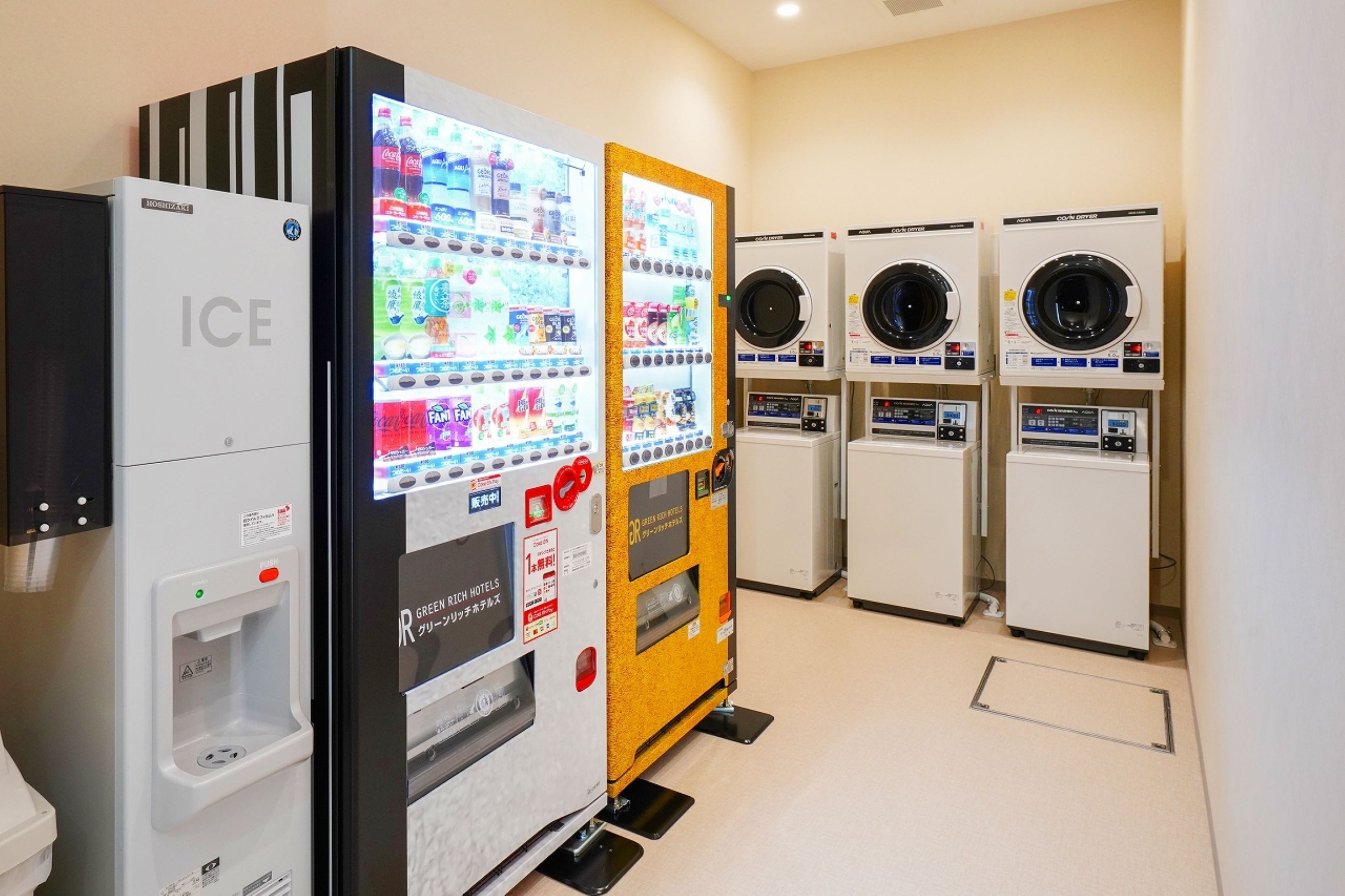 Quarto de hotel com máquina de vendas automática, máquina de lavar e secadora.