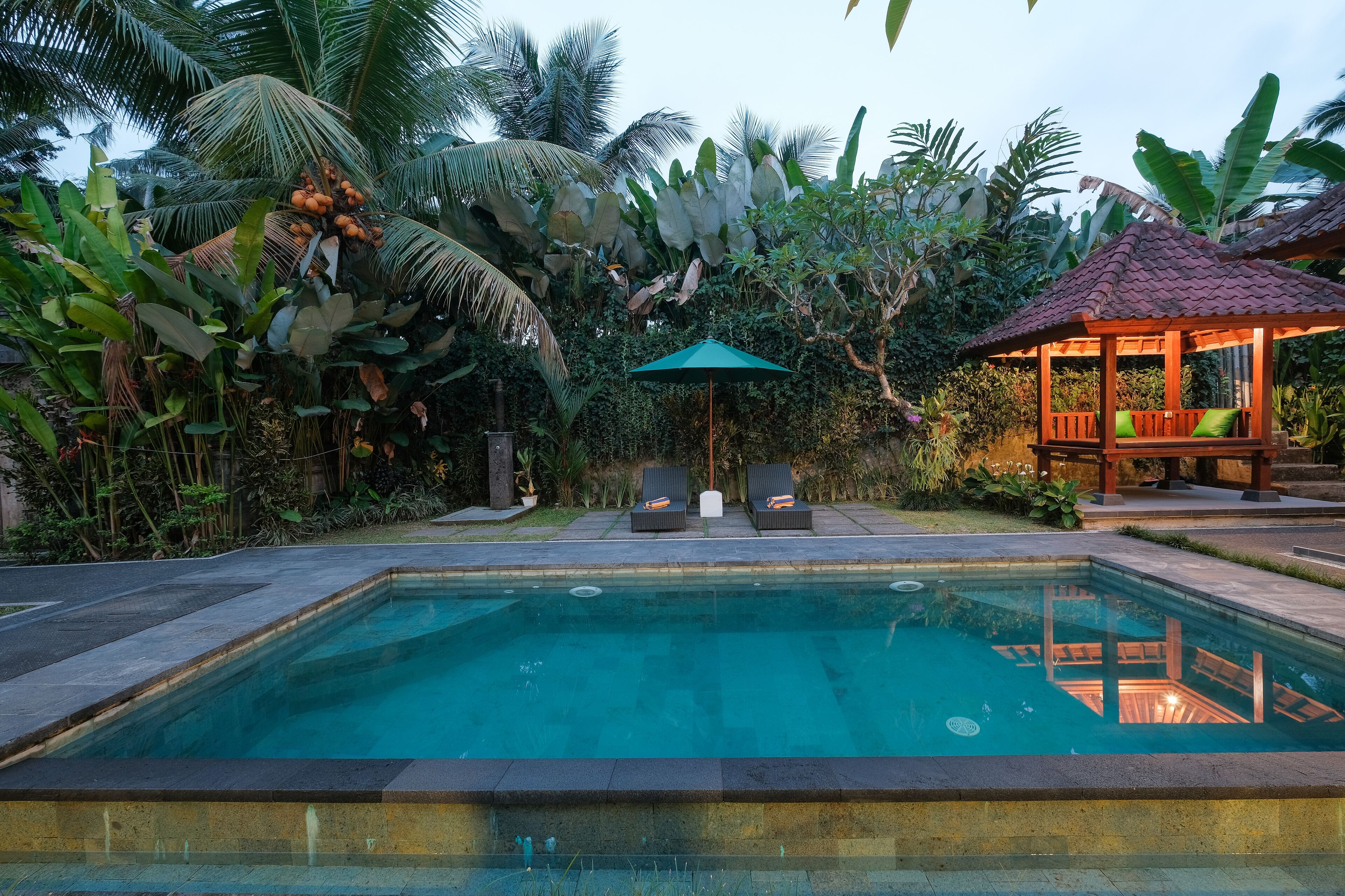 Uma área de piscina com espreguiçadeiras e um gazebo.