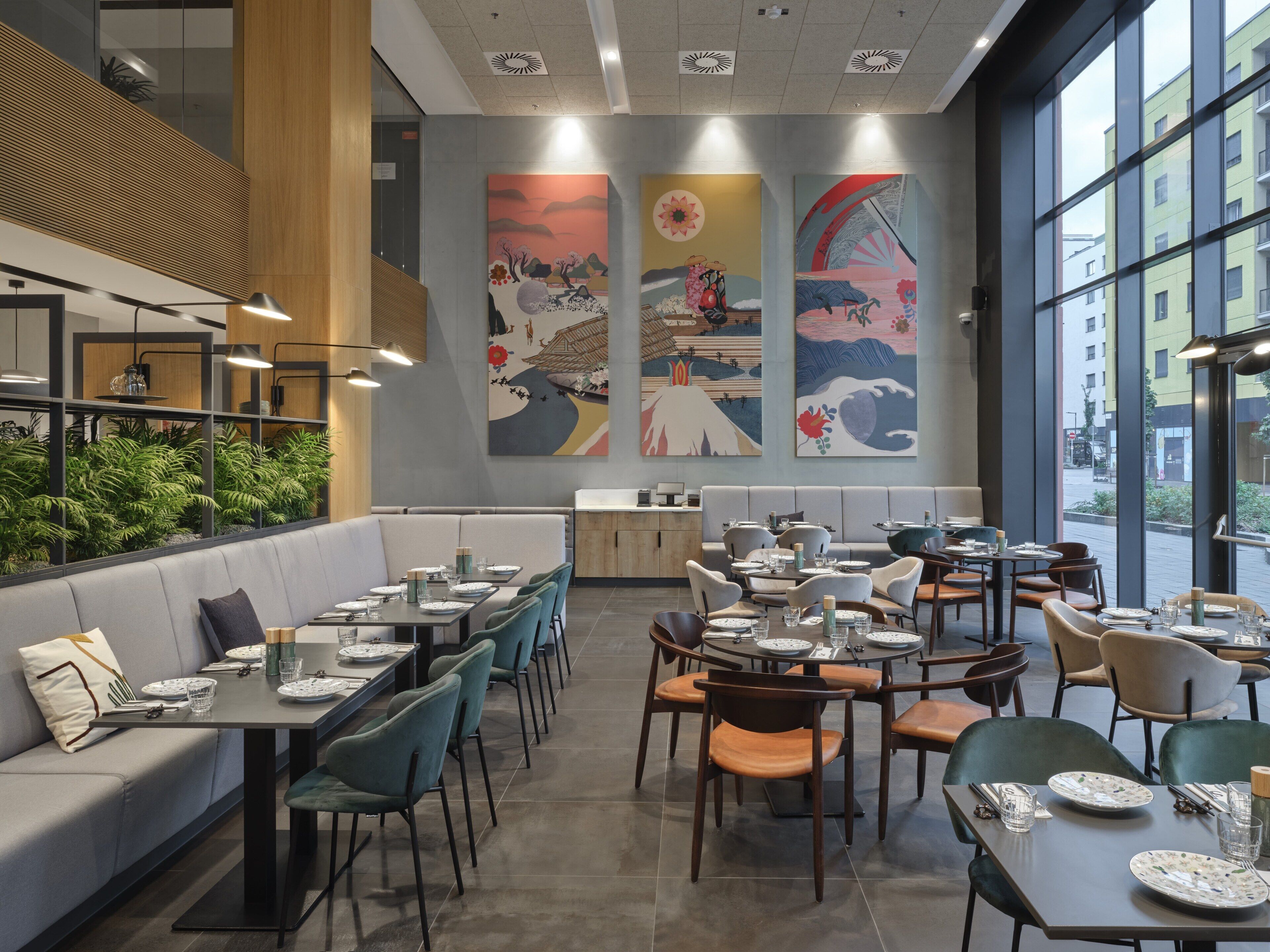 Restaurante moderno com pé-direito alto, grandes janelas e uma variedade de opções de assentos, incluindo cabines e mesas.