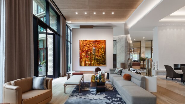 Uma sala de estar moderna com uma grande pintura abstrata, um sofá, uma mesa de centro e uma área de jantar.