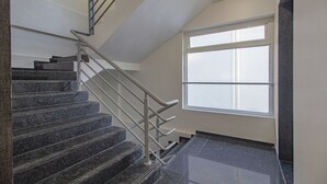 Uma escadaria com corrimãos de metal que leva a um patamar.