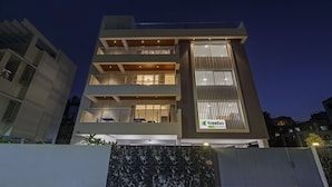 Um hotel moderno de vários andares com varandas, fachada de vidro vertical proeminente e o logotipo do 'treebo trend Alitli Comfort Inn'.