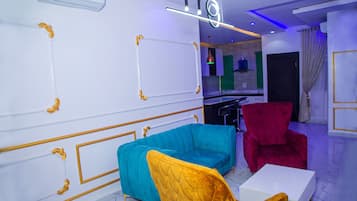 Uma sala de estar moderna com um sofá azul-turquesa, uma poltrona amarela e uma mesa de centro branca.