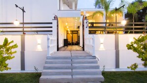 Um edifício moderno com uma escadaria que leva a uma entrada bem iluminada.