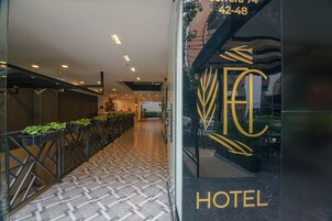 Entrada de hotel com design moderno, piso estampado e porta de vidro com um logotipo.
