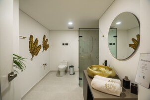Uma casa de banho moderna com sanita, lavatório e espelho.