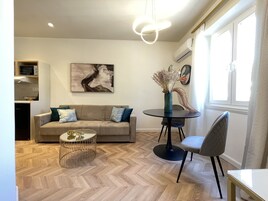 Uma sala de estar moderna com sofá, mesa de centro e espaço para refeições.