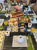 Um buffet de café da manhã com diversos pães, bolos e bebidas.