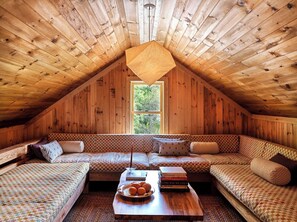 Um quarto de sótão aconchegante, com paredes de madeira e teto inclinado.