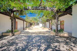 Um caminho coberto que leva a um edifício com pérgola.