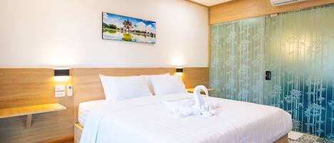 Quarto de hotel com uma cama grande, um quadro na parede e piso estampado.
