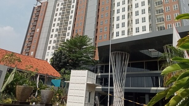 Um edifício residencial alto com várias sacadas e design arquitetônico moderno.