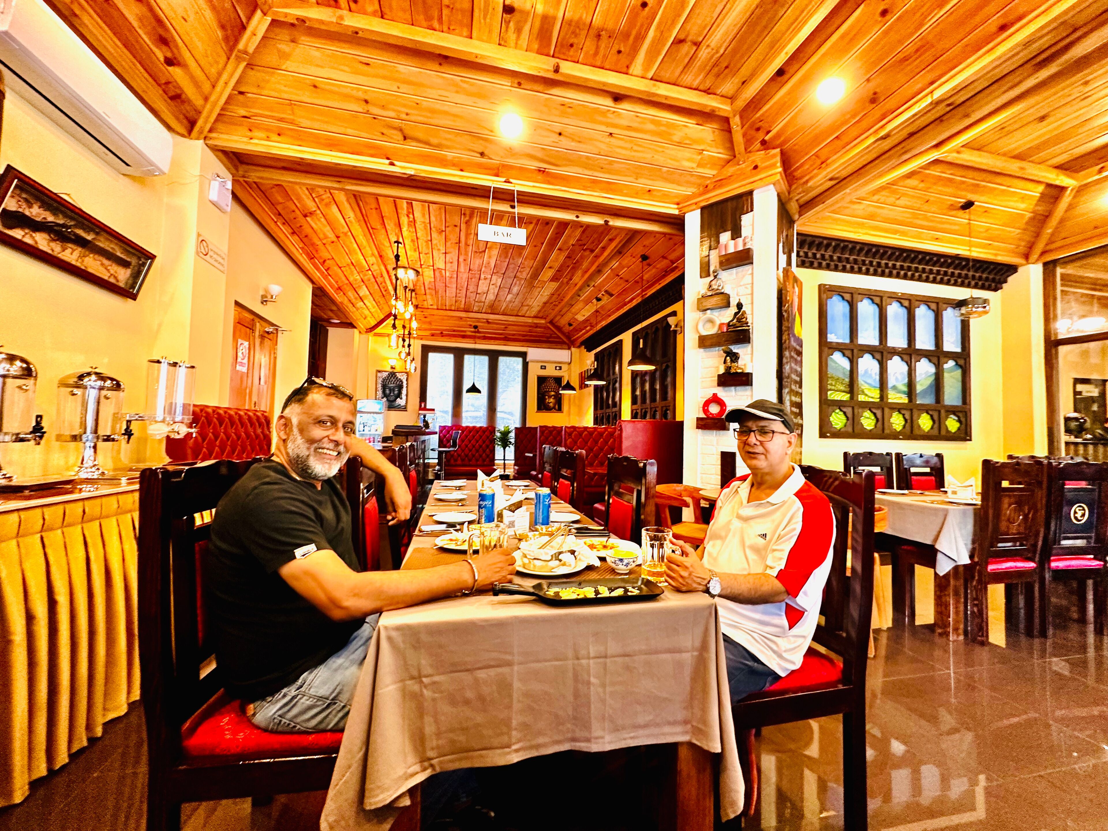 Restaurante com tetos de madeira e assentos acolchoados vermelhos.
