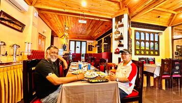Restaurante com tetos de madeira e assentos acolchoados vermelhos.