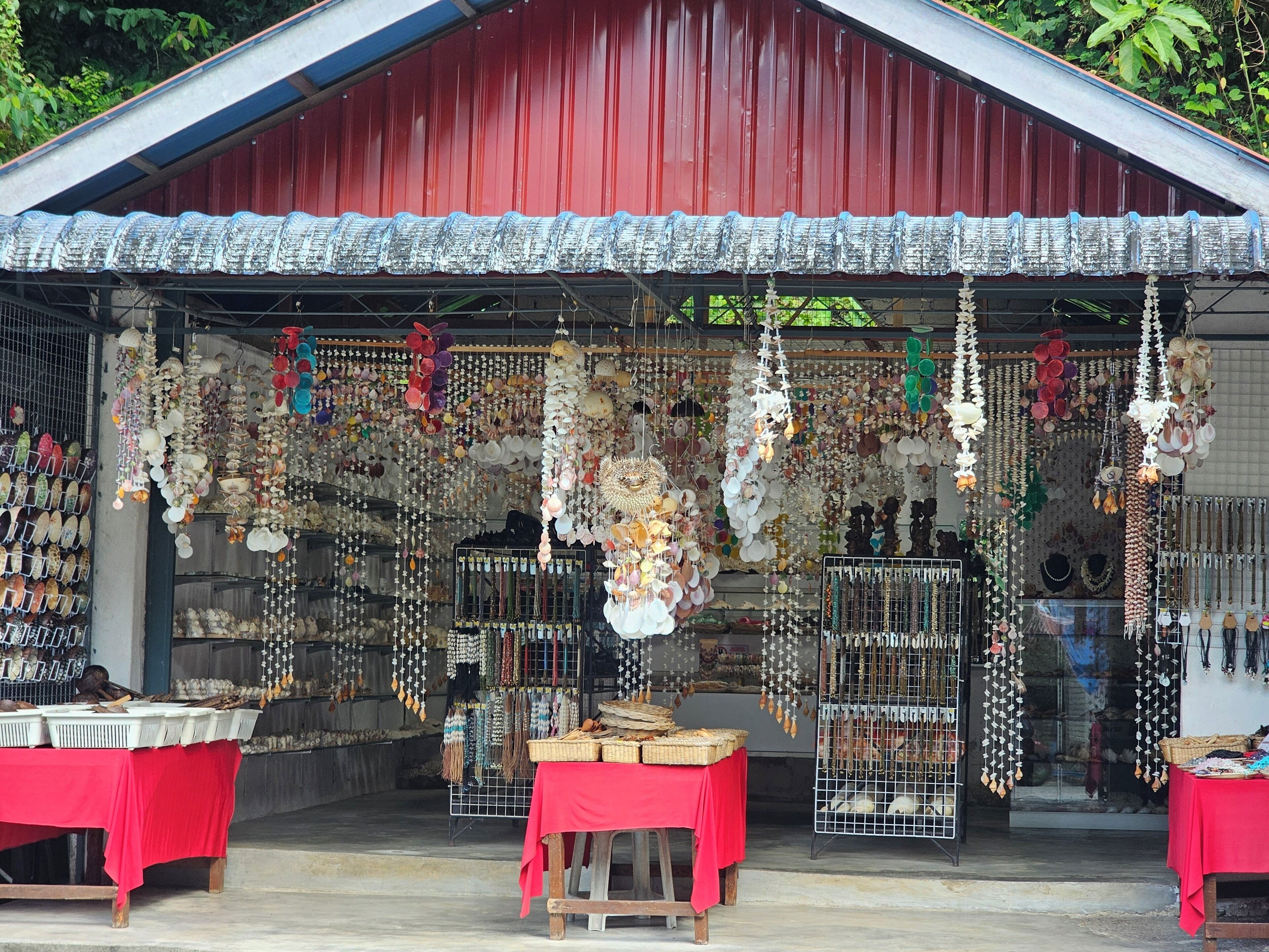 Uma banca de mercado com vários artigos expostos, incluindo joias e objetos decorativos.