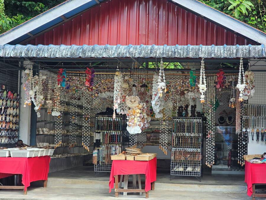 Uma banca de mercado com vários artigos expostos, incluindo joias e objetos decorativos.