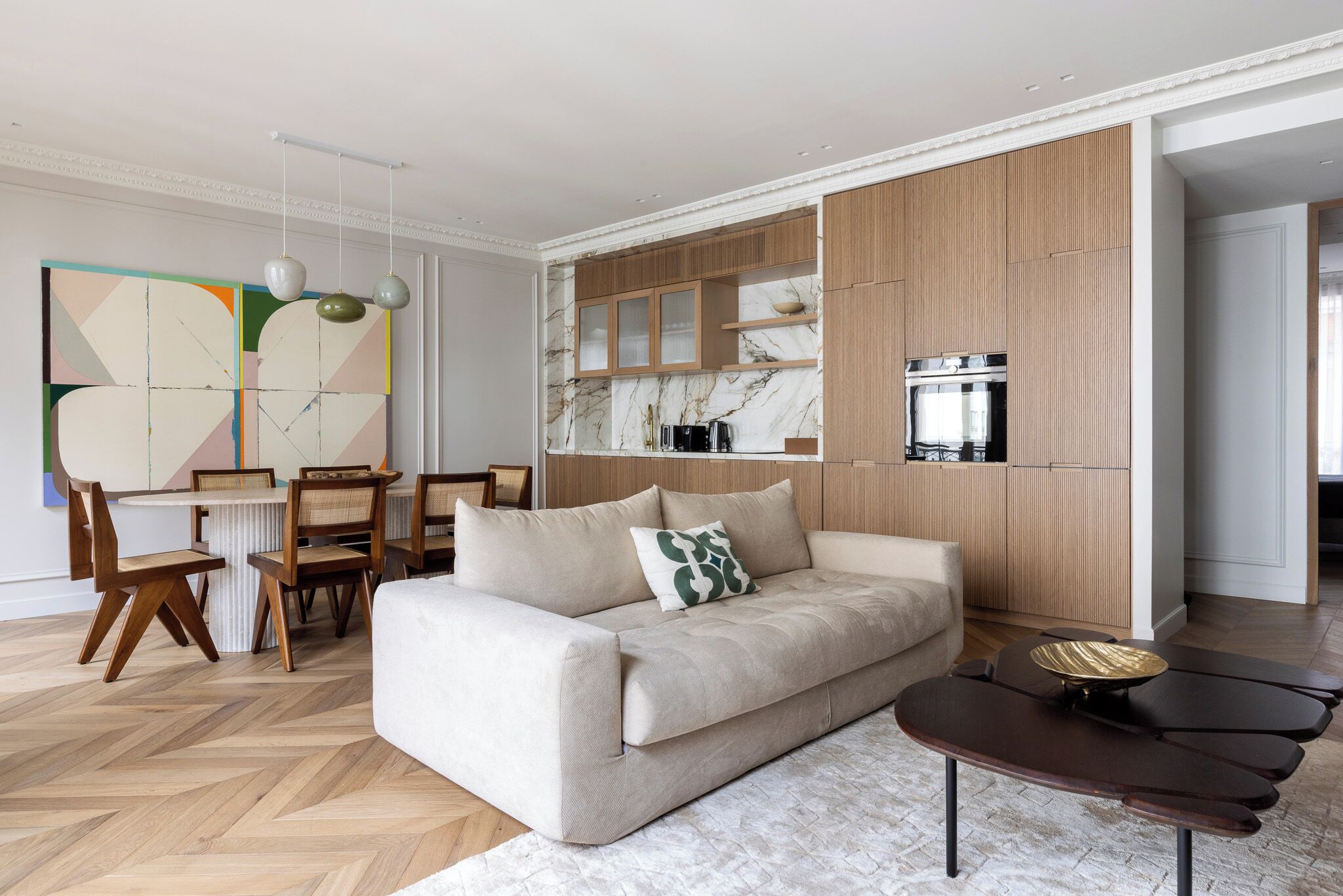 Uma sala de estar moderna com sofá, mesa de centro e área de jantar com cadeiras e mesa.