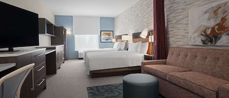 Quarto de hotel com cama, escrivaninha, televisão, sofá e um quadro na parede.