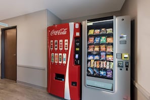 Máquina automática de vendas com o logotipo da Coca-Cola e um visor digital.