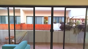 Quarto com porta de vidro deslizante que dá para uma varanda com vista exterior.