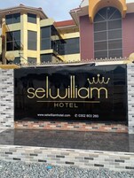 Placa de hotel com o nome 'Selwilliam Hotel' e informações de contato.