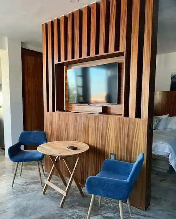 Apartamento Deluxe, 1 cama king-size, cozinha, vista parcial para o mar | Sala de estar | Livros, aparelhagem