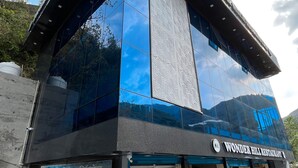 Um edifício moderno com fachada de vidro e uma placa indicando 