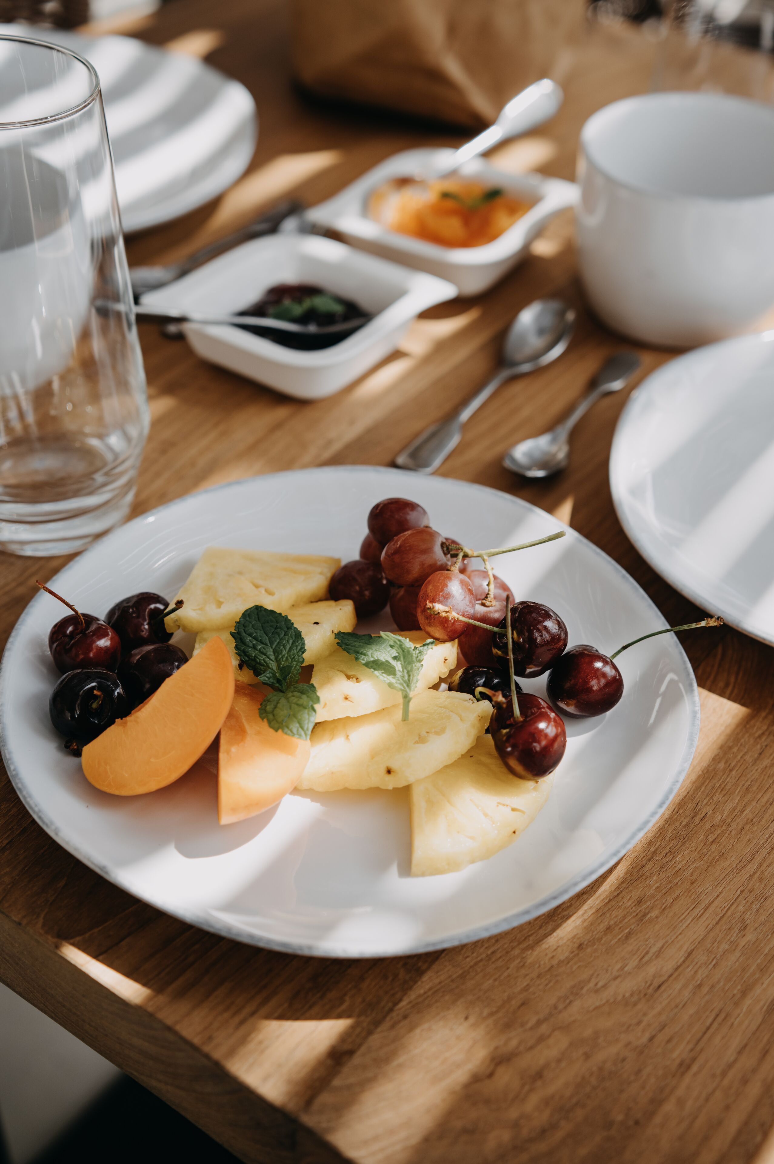 Uma tábua de frutas e queijos sobre uma mesa de madeira.