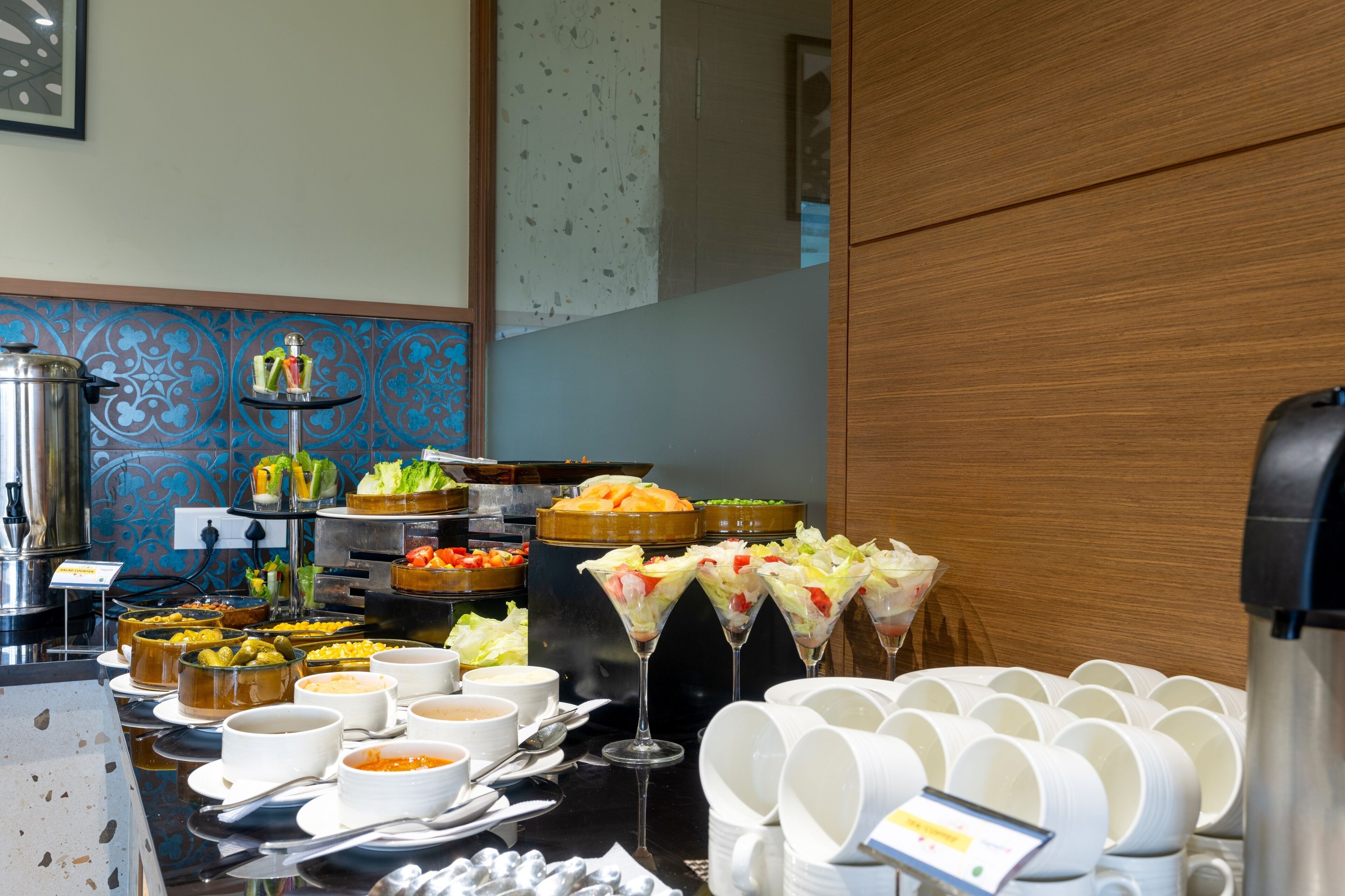 Disposição de buffet com diversos alimentos e bebidas.