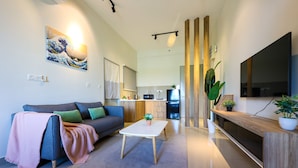 Uma sala de estar moderna com sofá, mesa de centro e televisão de tela plana.