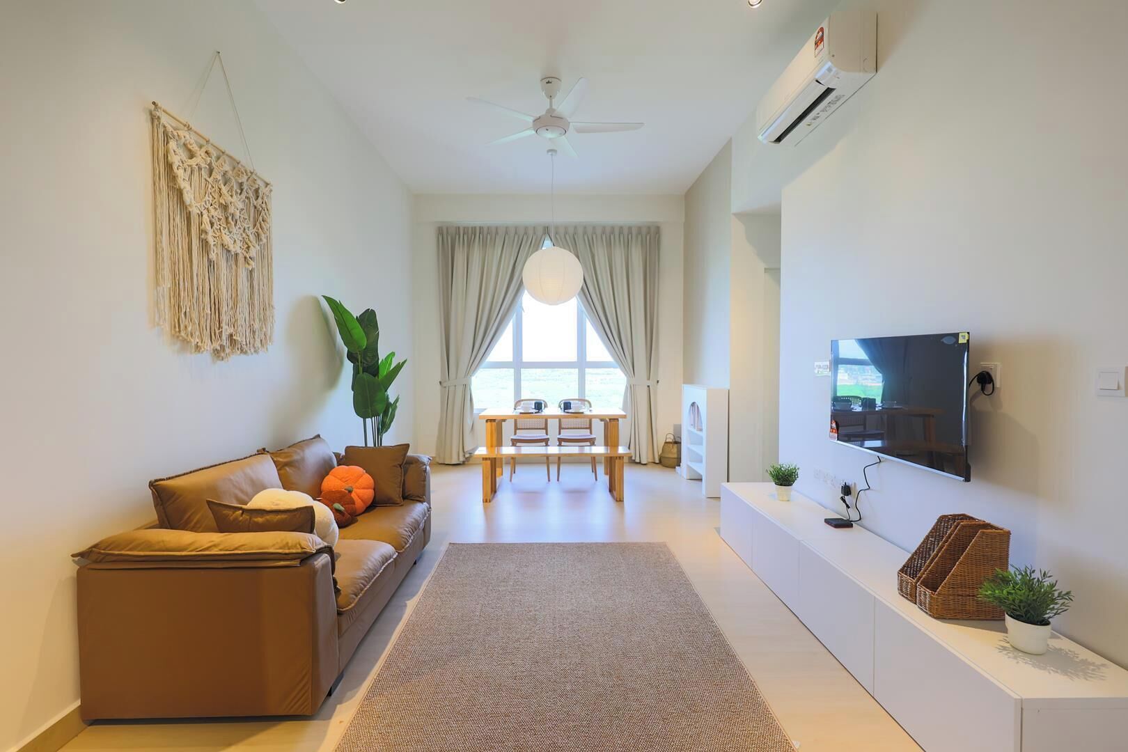 Uma sala de estar moderna com um sofá, uma mesa de jantar e uma televisão.