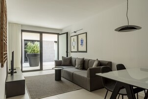 Apartamento executivo, 2 quartos | Área de estar | Smart TV 50 polegadas com canais digitais