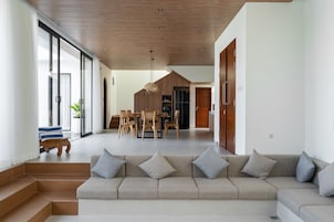 Uma sala de estar moderna com sofá, área de jantar e escada.