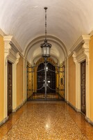 Um corredor com piso lustroso, um portão de metal decorativo e um pendente.