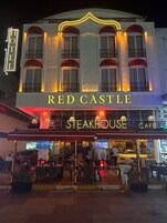 Exterior do Hotel Red Castle, com um letreiro visível para o Café Steakhouse.