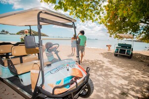 Perto da praia, areia branca, espreguiçadeiras, guarda-sóis 