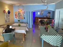 Uma área de refeições com mesas, cadeiras e um bar.