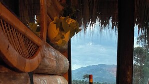 Uma mesa de madeira rústica com uma garrafa de vinho, duas taças e uma cafeteira.