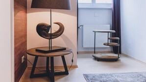 Quarto moderno com uma luminária original, um arranhador para gatos em vários níveis e vista para uma janela com cortinas.