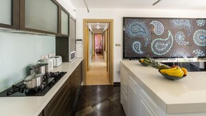 Uma cozinha moderna com uma ilha central, micro-ondas, fogão e um grande painel decorativo.