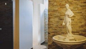 Um corredor com uma estátua de mulher sobre um pedestal.