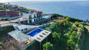 Uma casa moderna com piscina, com vista para a costa.