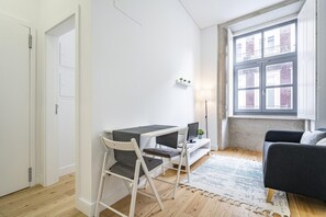 Quarto moderno com escrivaninha, cadeira e sofá.