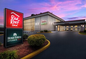 Um hotel com uma grande placa para Red Roof Inn e Home Towne Studios.