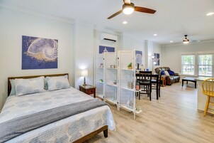 Quarto com cama, ventilador de teto e mesa de cabeceira.